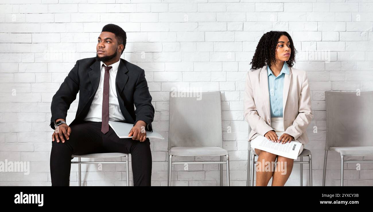 Black man and woman looking in opposite directions, feeling competitive ...