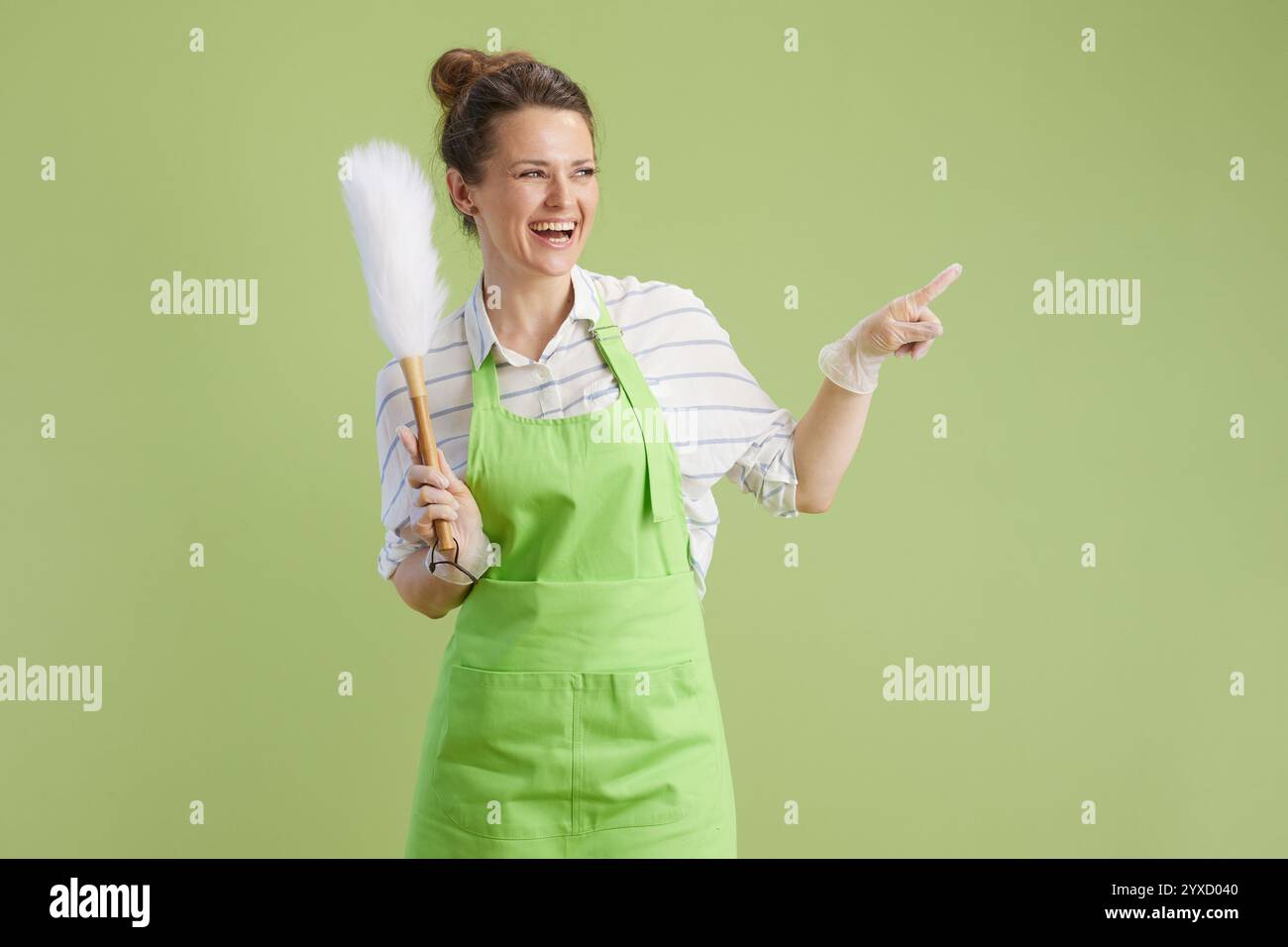 Spring cleaning. smiling modern woman in green apron and rubber gloves ...