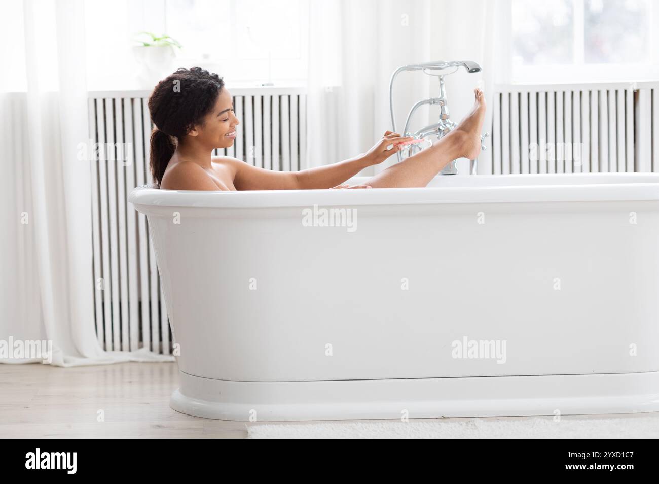 Relaxing woman enjoys pampering while caring for her skin in a stylish ...