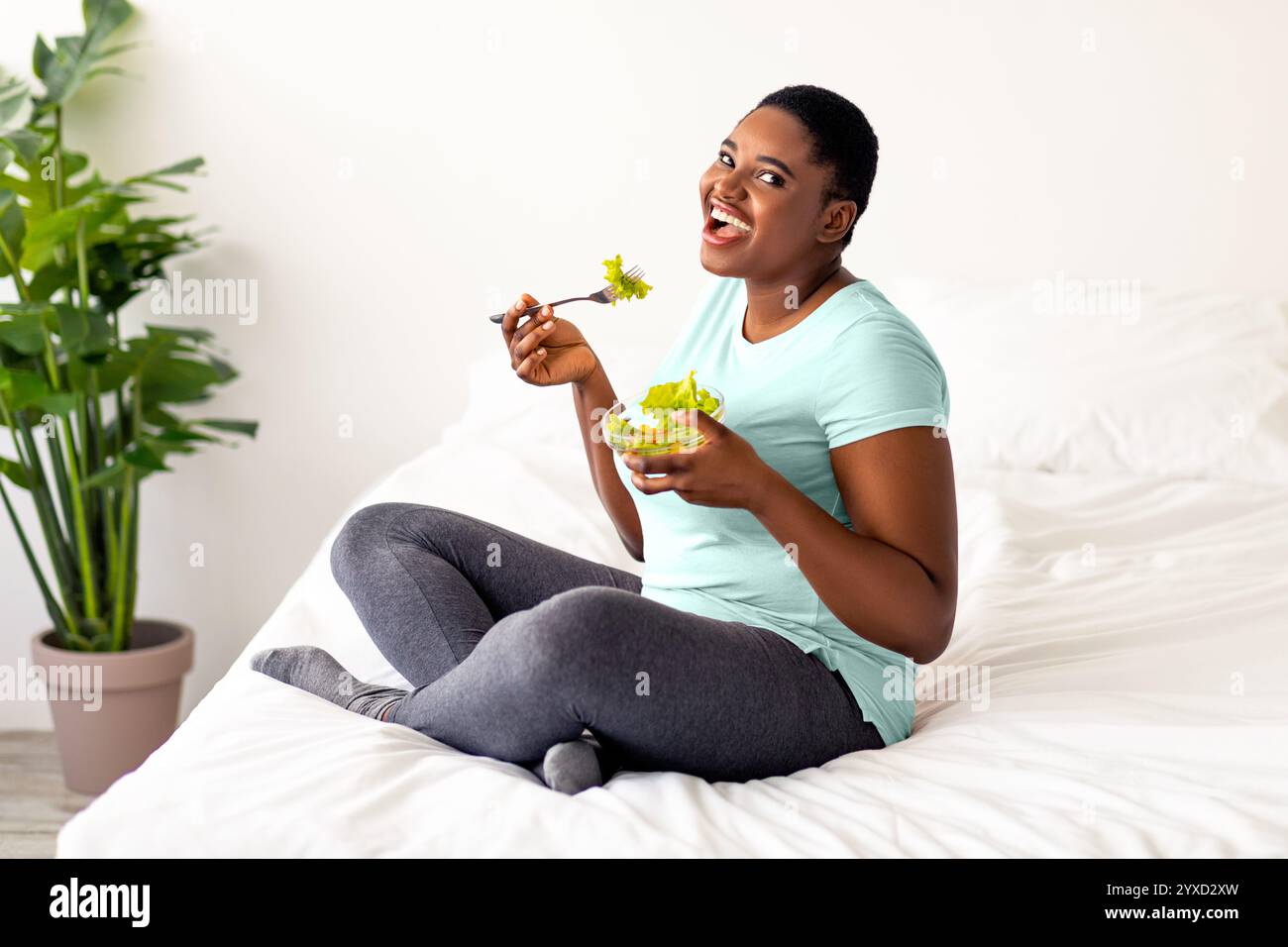 Balanced slimming diet concept. Overweight black woman eating vegetable ...