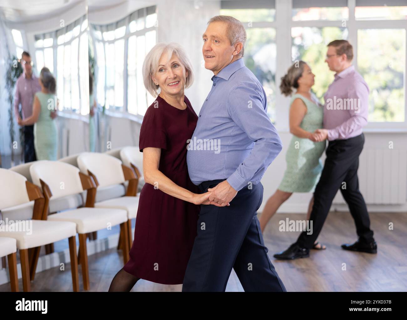 Pairs of mature amateur dancers enthusiastically performs romantic ...