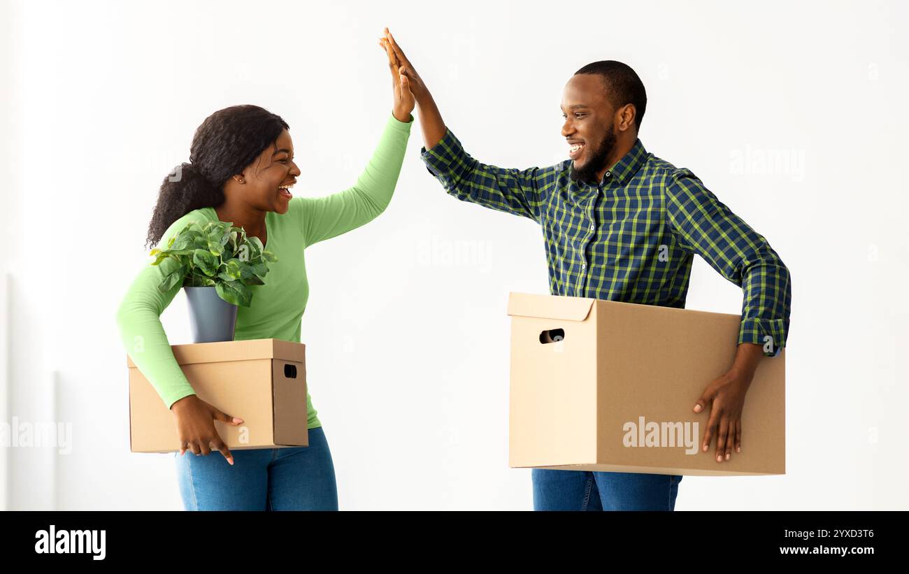 Moving Day. Joyful Black Spouses Holding Cardboard Boxes And Giving ...