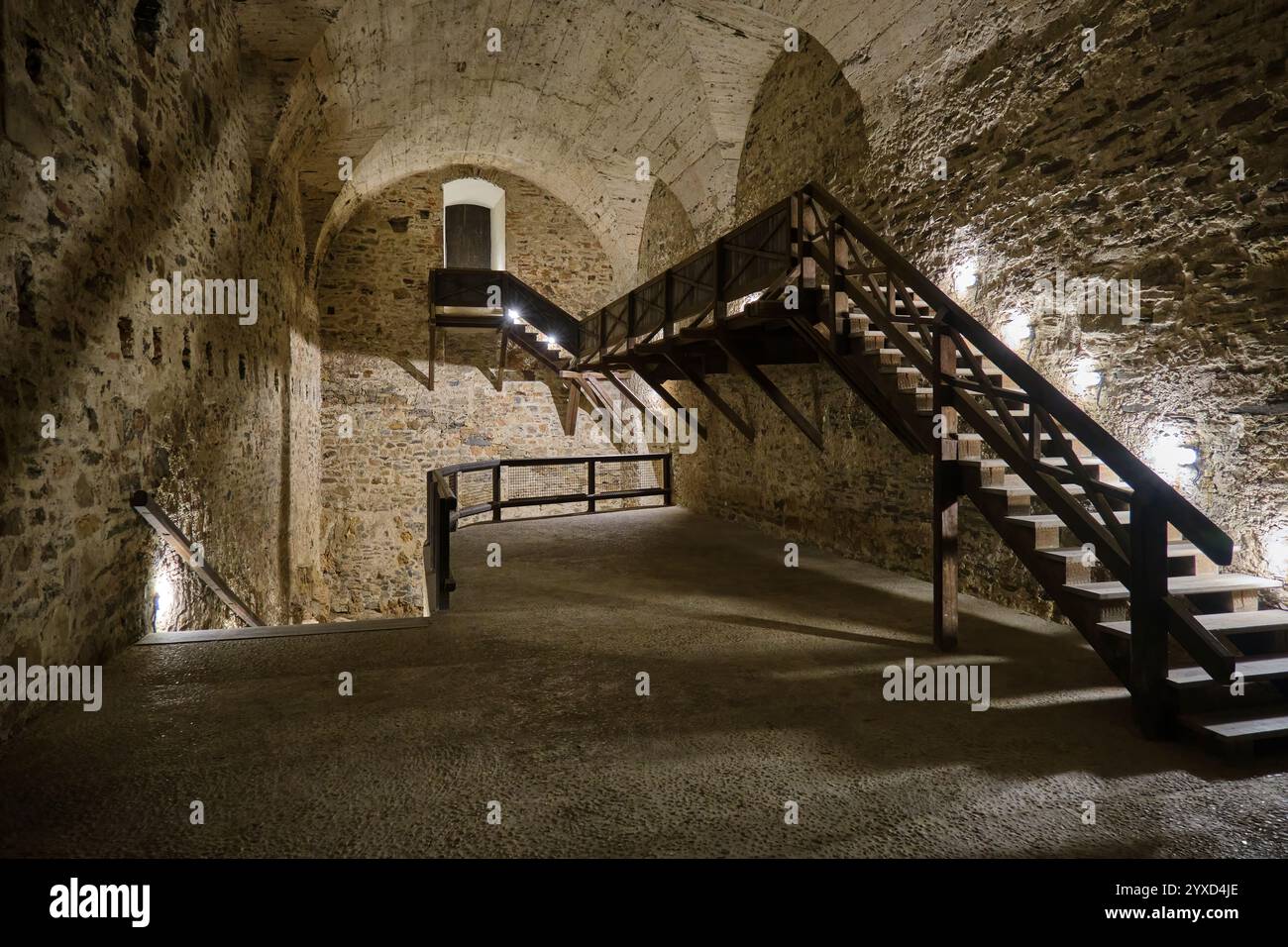 Wooden stairs rise along a wall in the large cellars of the Red Stone ...