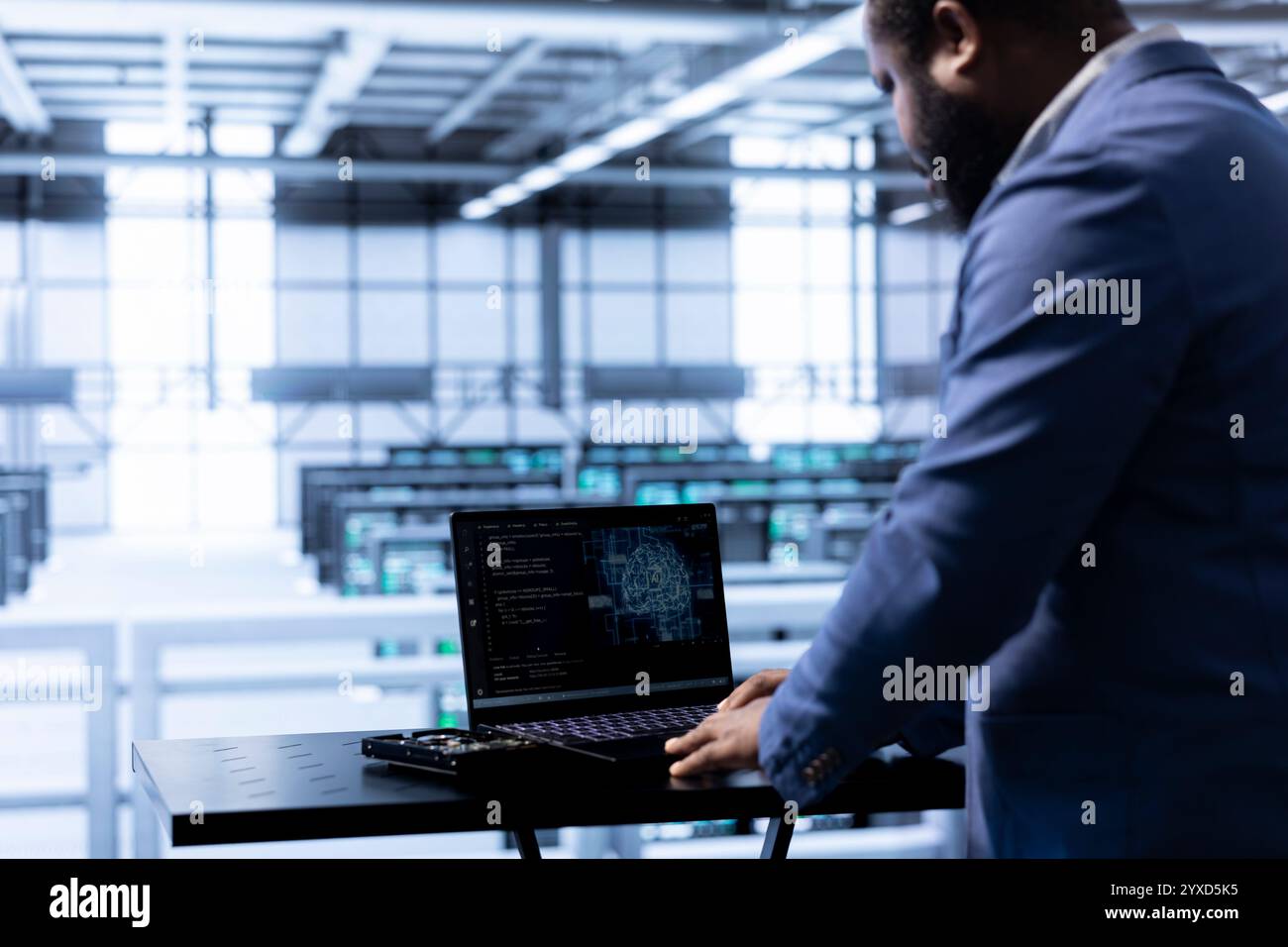 Computer scientist in data center using laptop to visualize artificial ...