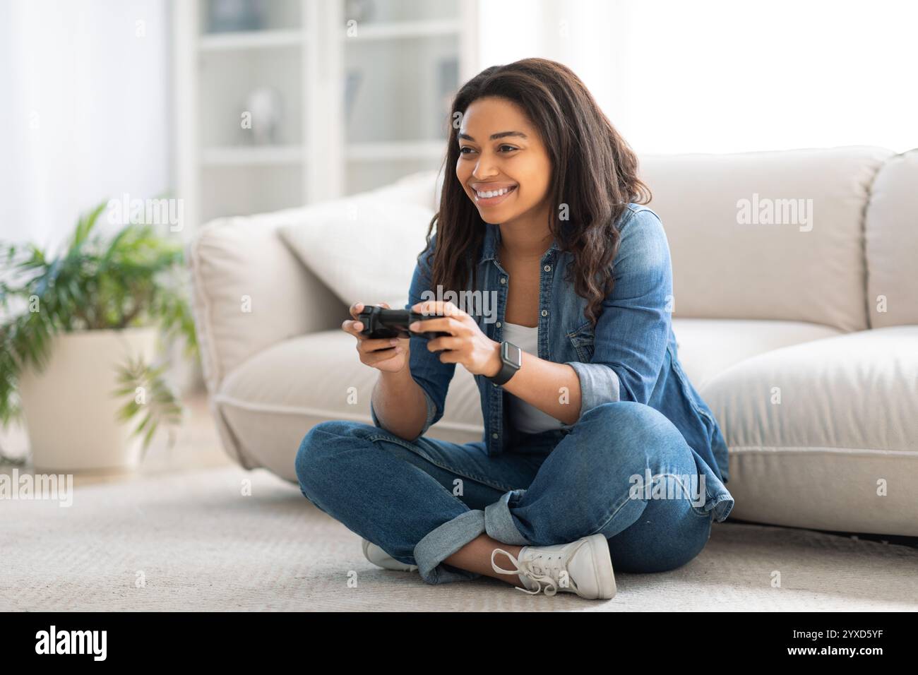 Young woman enjoying gaming at home in a cozy living room setting Stock ...