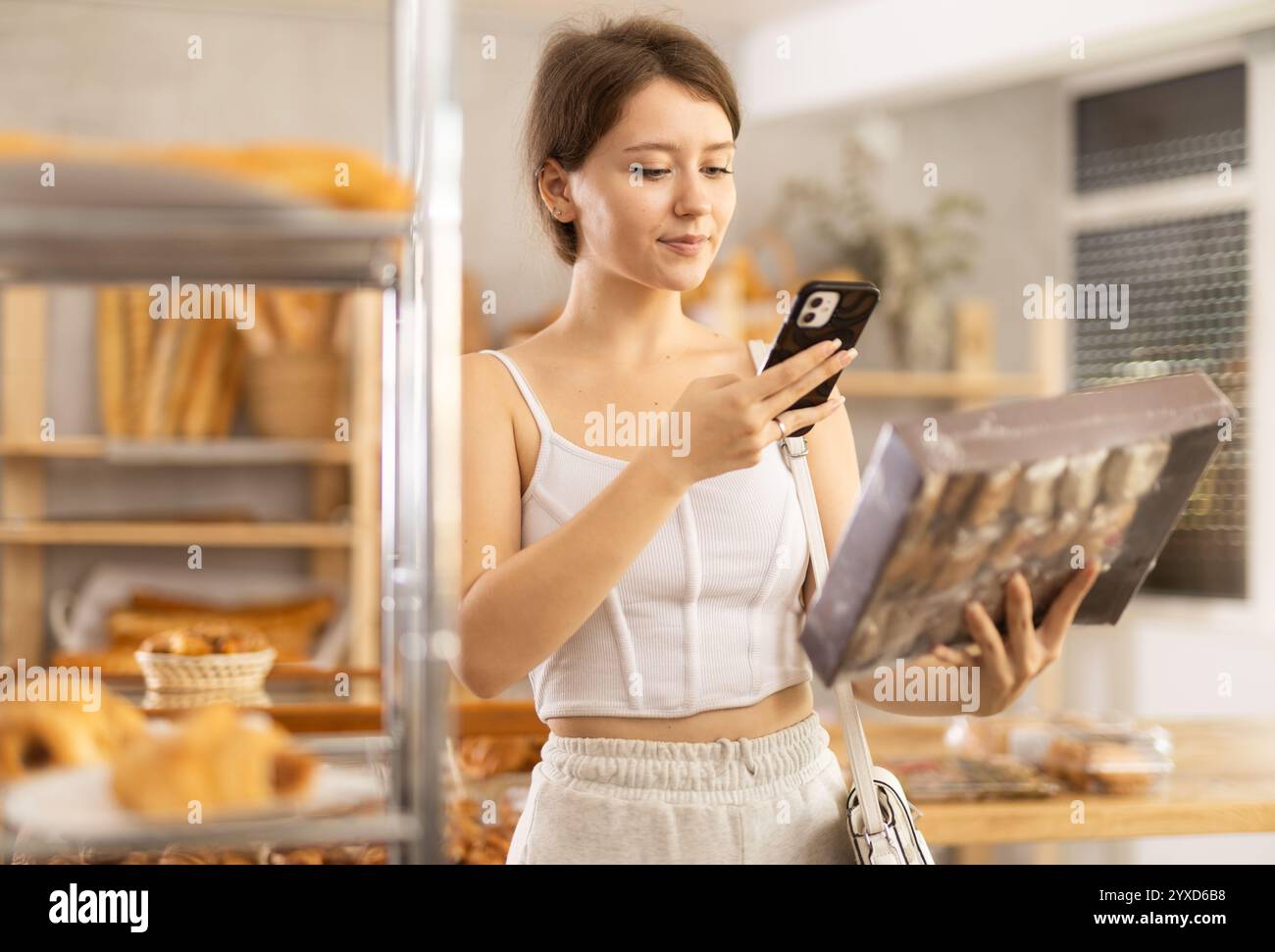 Female customer scanning QR code on label of fresh baked goods in ...