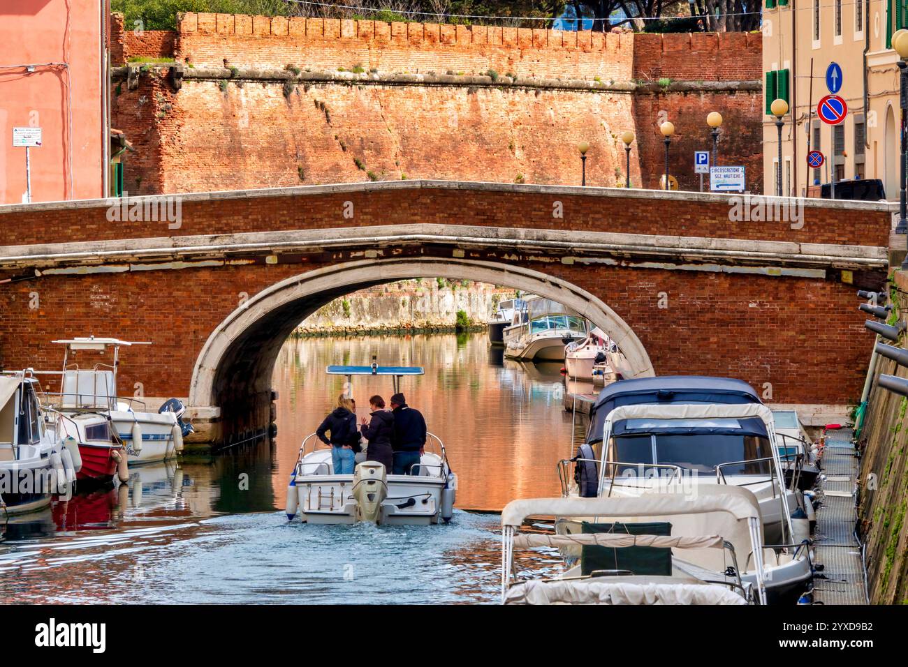 A tourist boat navigates the historic canals of Venezia Nuova in ...