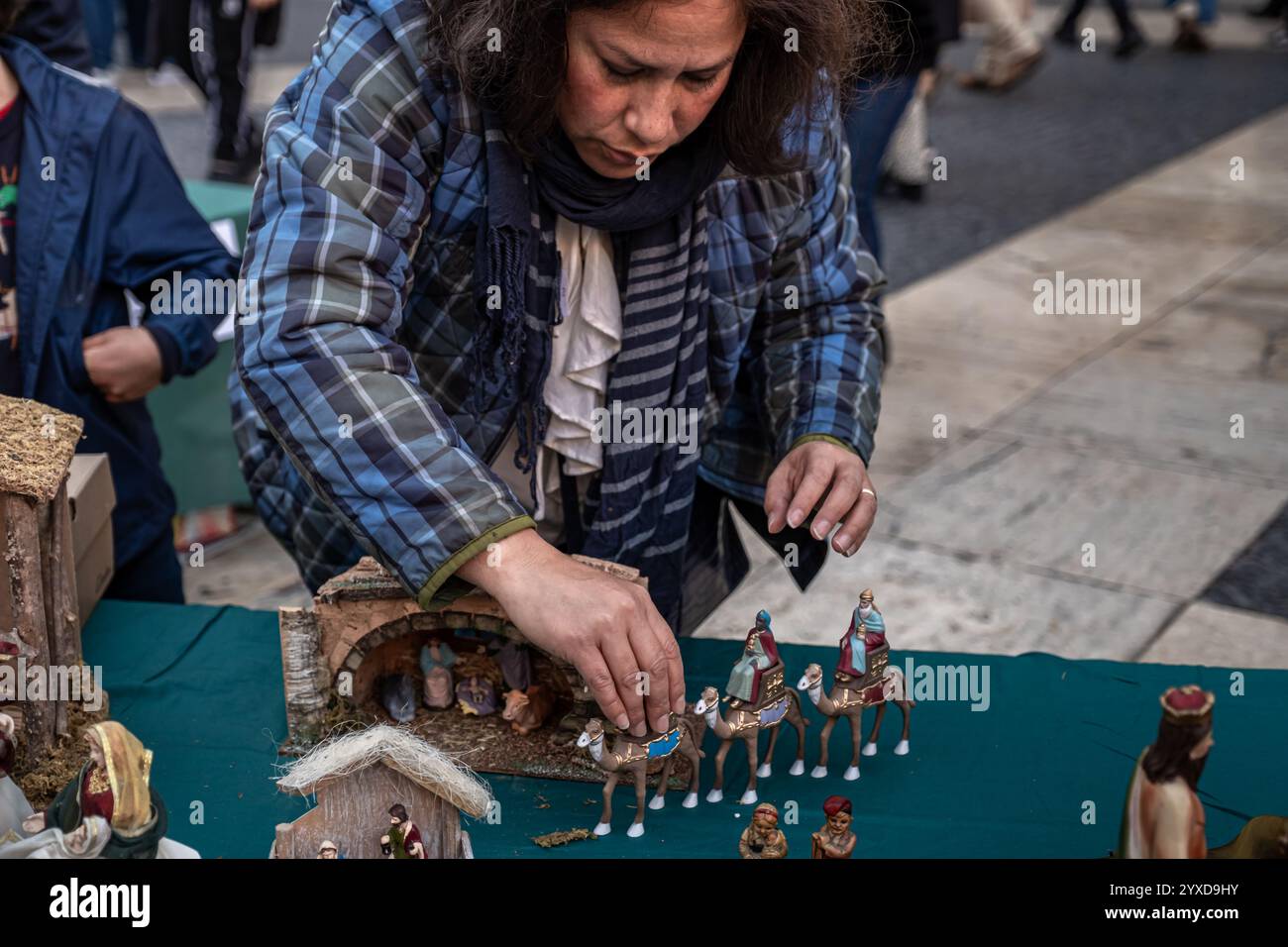 A woman is seen placing the Three Wise Men from the East on the counter ...