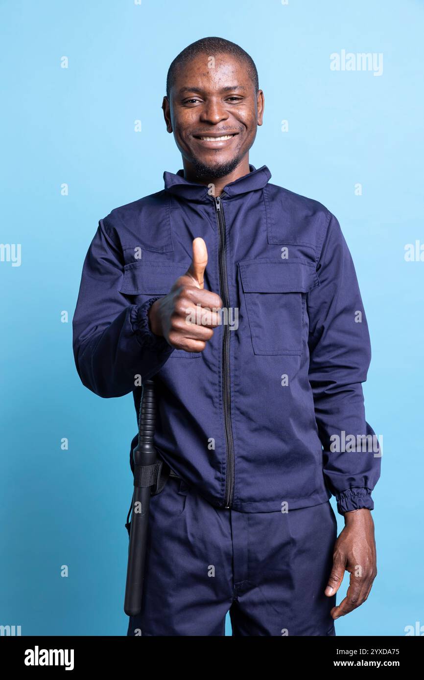Happy confident security agent showing a thumbs up sign in studio ...