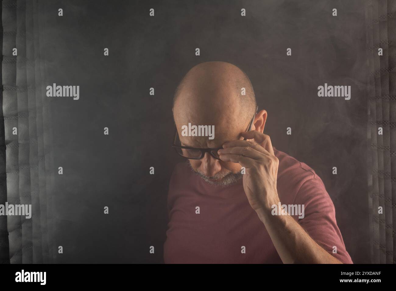 Bald and bearded man making expressions with his head down in a studio ...