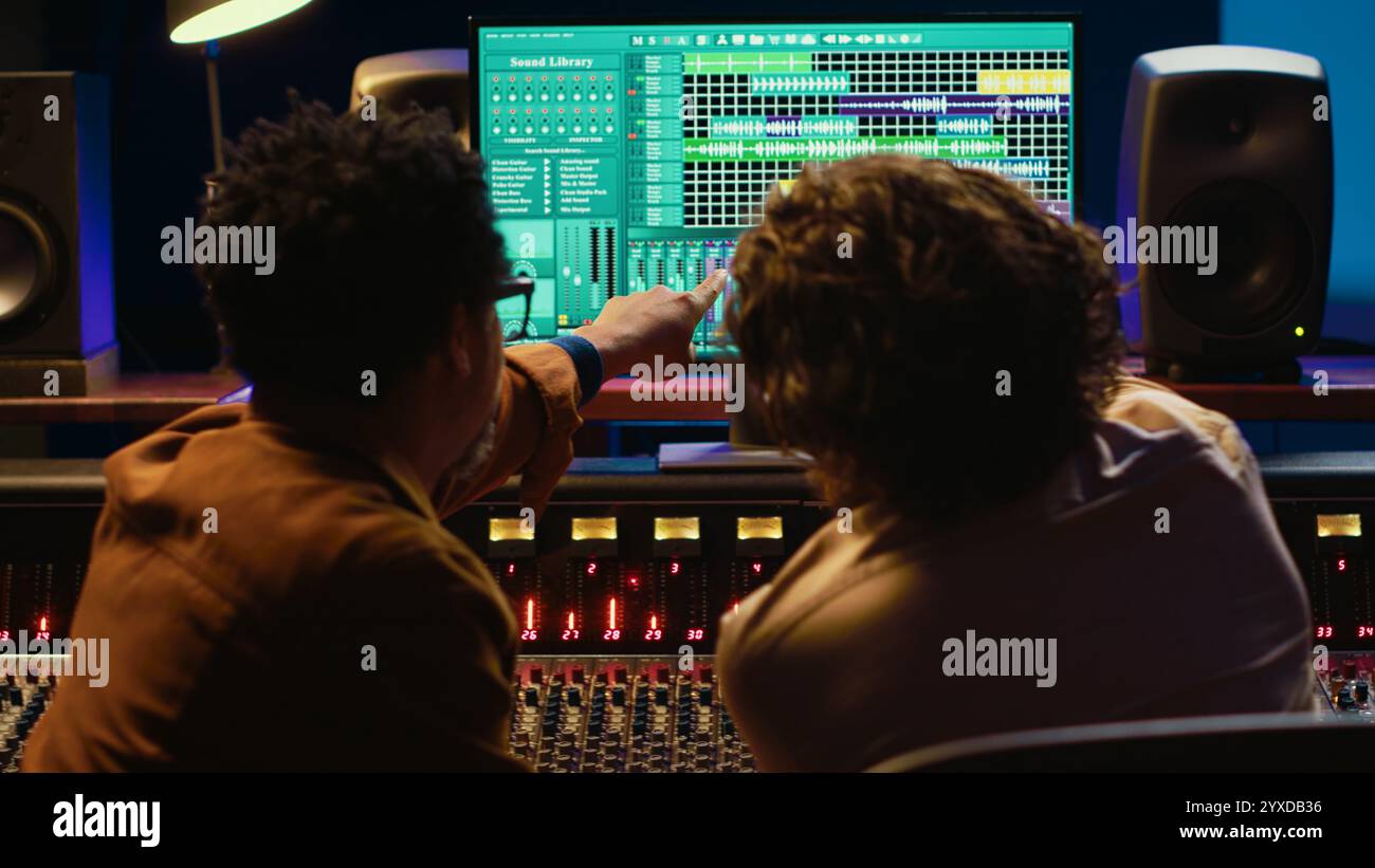 Diverse people processing and mixing sounds on audio console, adding ...