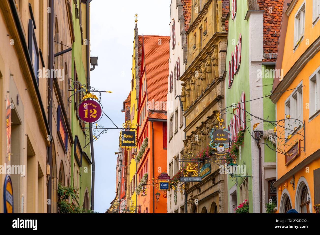 Medieval Guild signs attached to colorful half-timbered buildings with ...