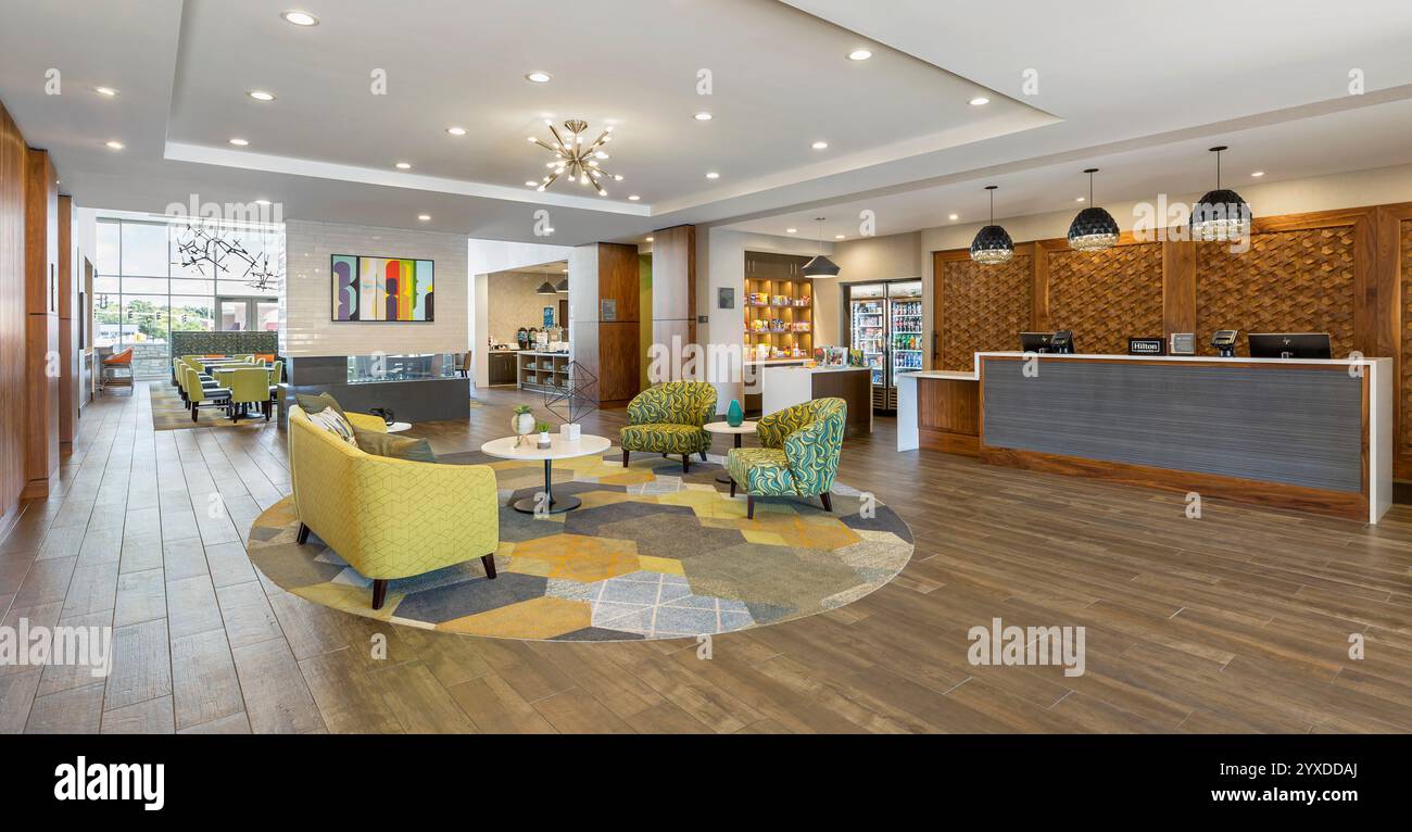 Lobby of hotel with round seating area in middle and dining area in ...