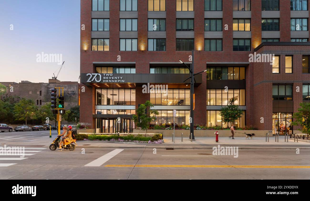 Front entrance of residential apartment tower at dusk with lights on ...