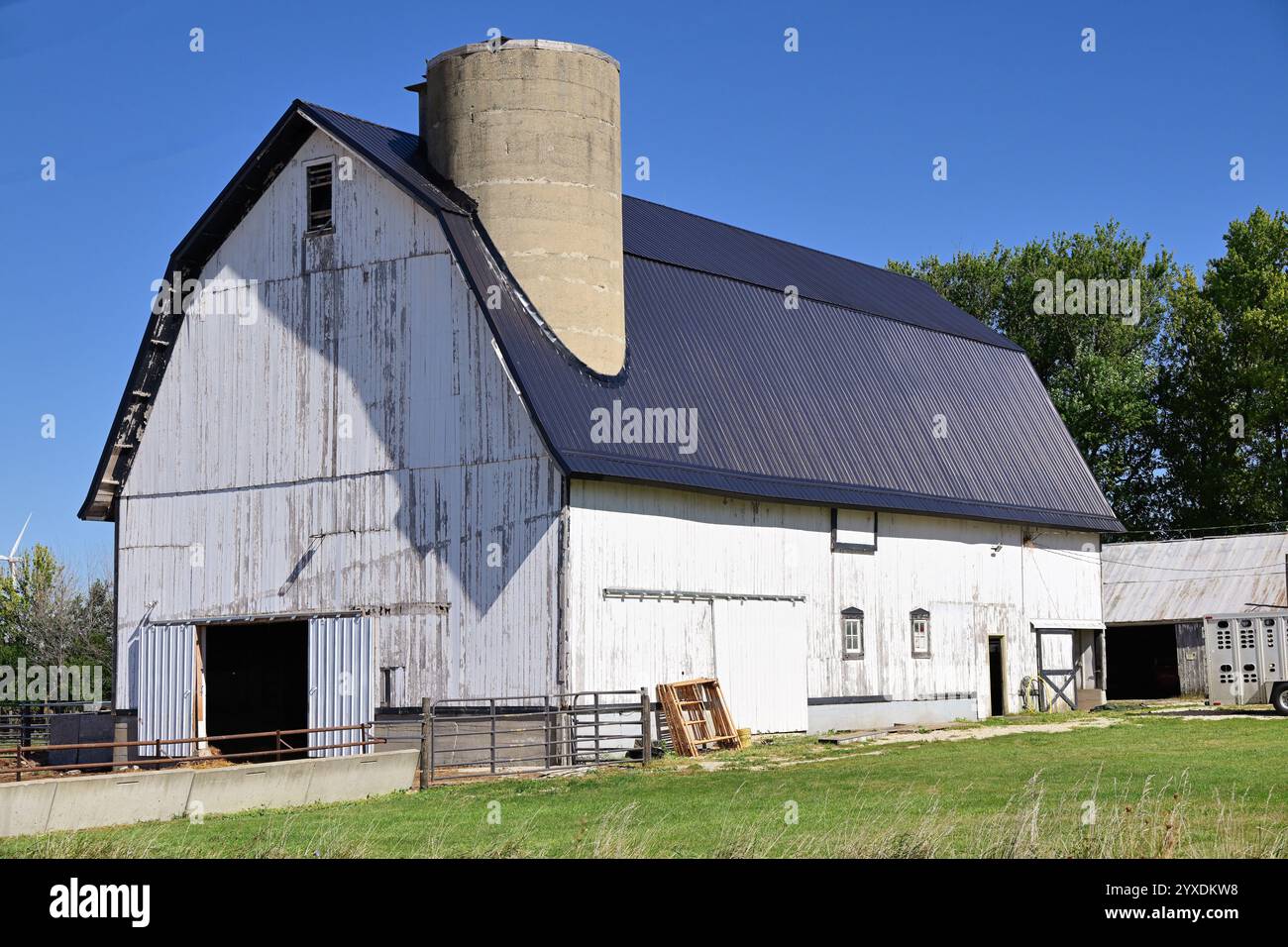 Lee, Illinois, USA. A weathered white barn sits within a field along a ...