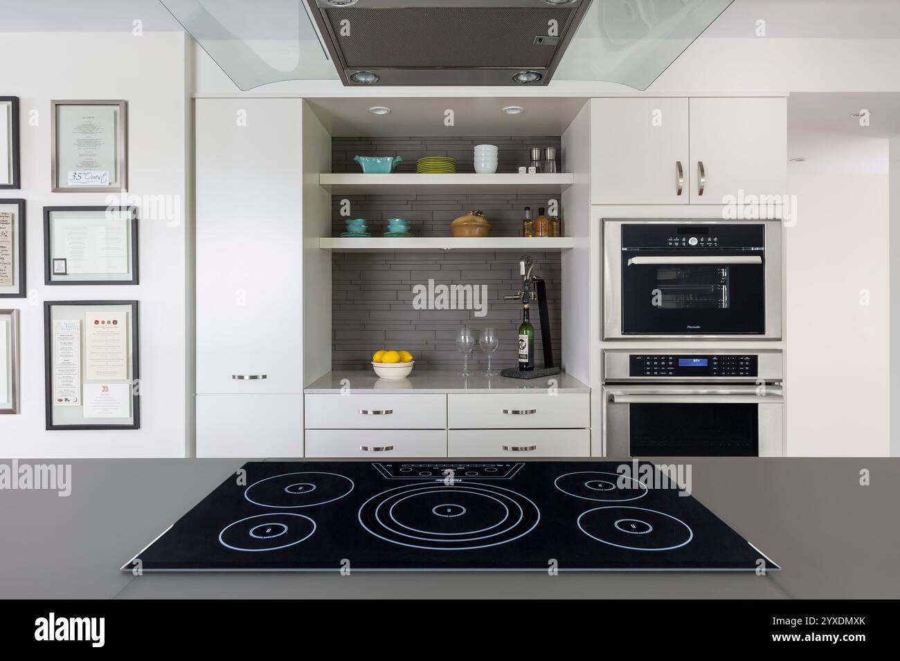 Smooth top cooktop on kitchen island with wall ovens and kitchen ...