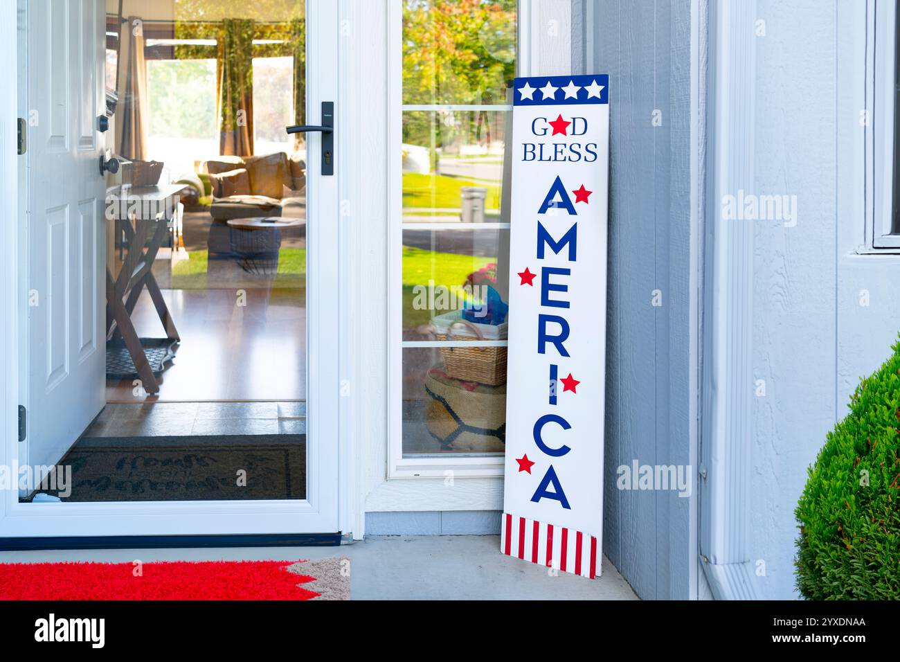 A suburban American home with the front door open showing patriotic ...