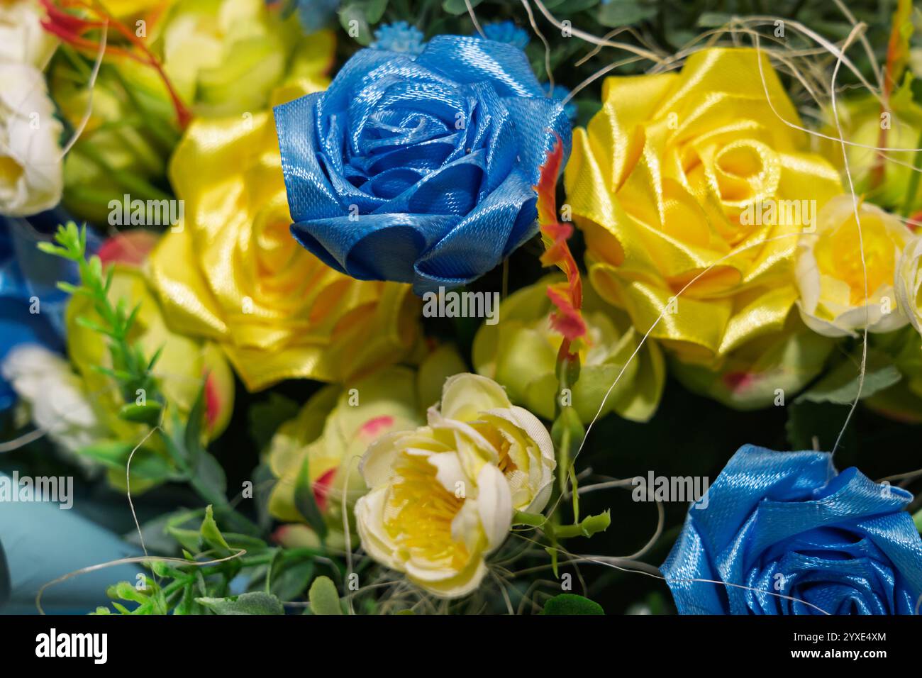 A vibrant collection of artificial blue and yellow roses is ...