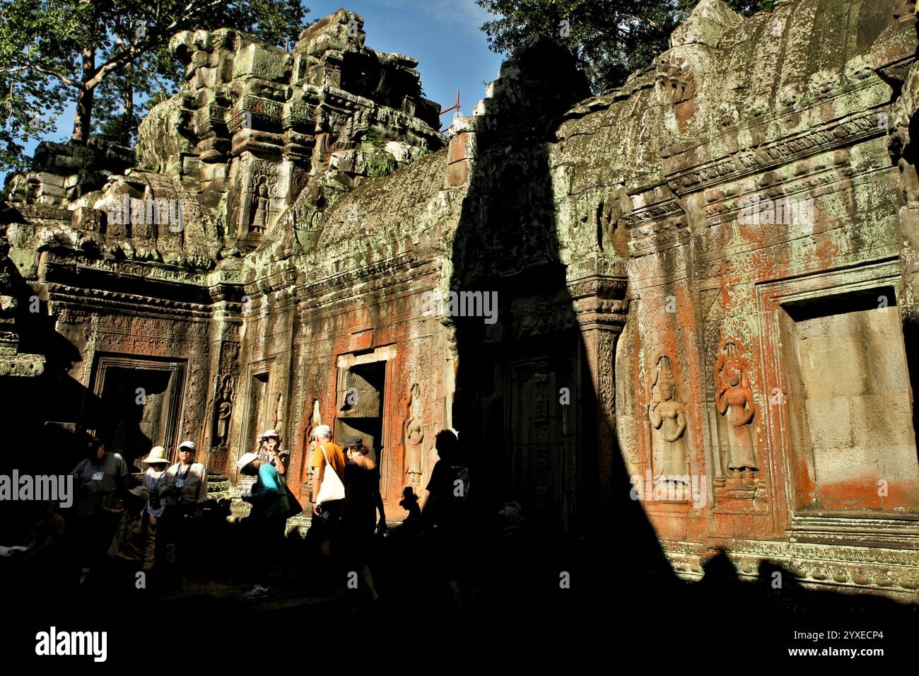 A group of tourists exploring a corner section of Ta Prohm, an ancient ...