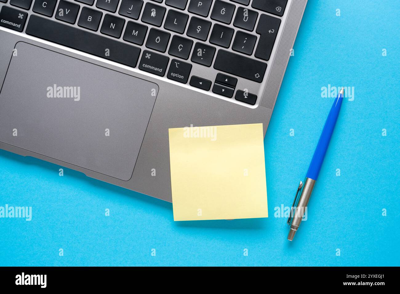 Top view of blank post-it stuck on laptop on blue table Stock Photo - Alamy