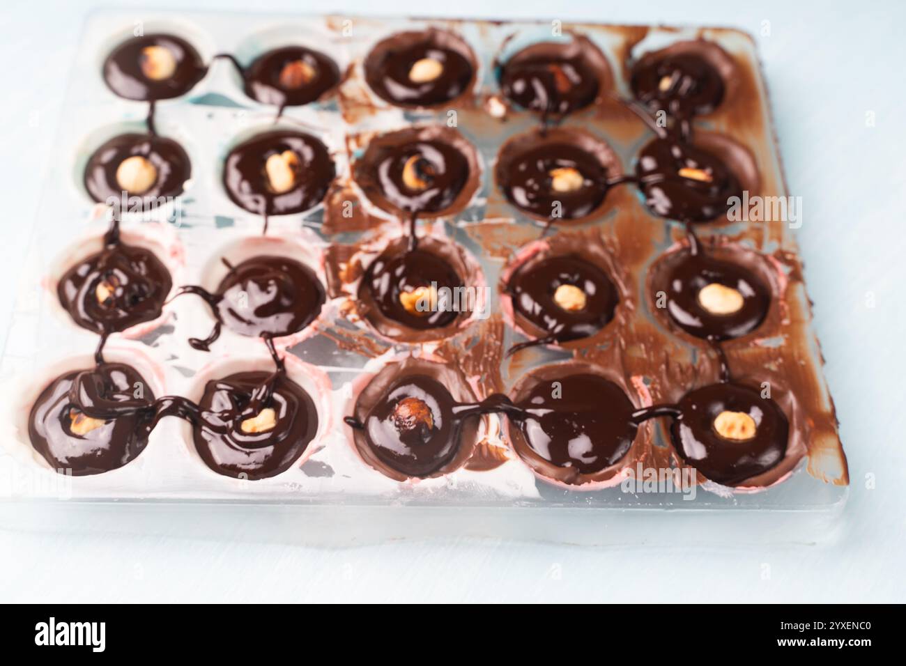 The nut mold is filled with tempered chocolate and ganache. The process ...