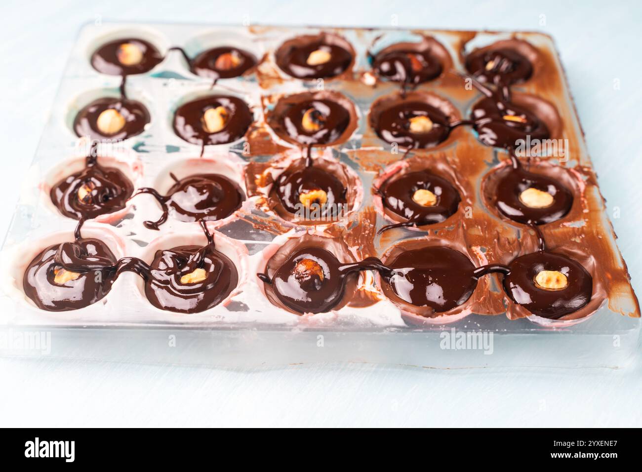 The nut mold is filled with tempered chocolate and ganache. The process ...