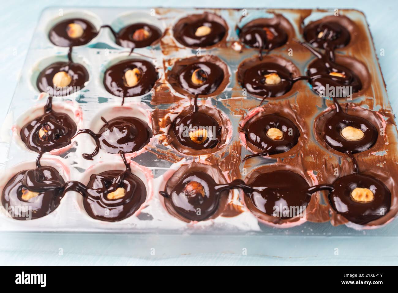 The nut mold is filled with tempered chocolate and ganache. The process ...
