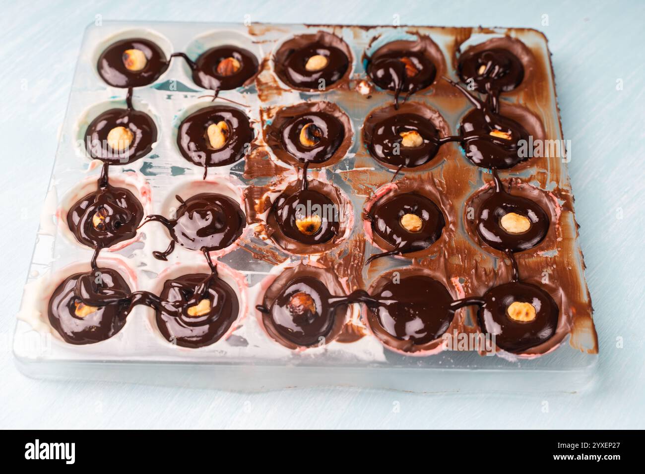 The nut mold is filled with tempered chocolate and ganache. The process ...