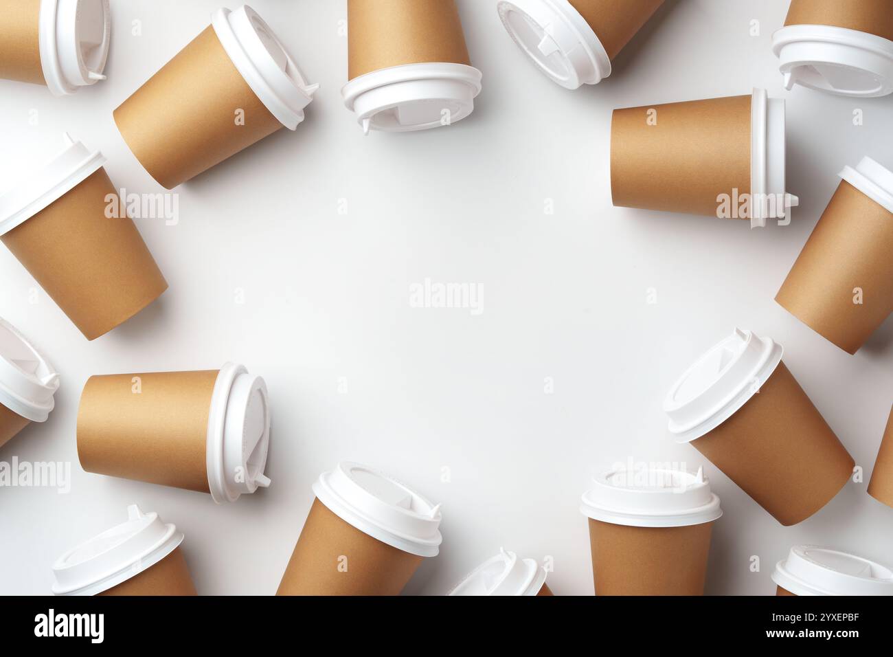 A circle of disposable coffee cups arranged neatly on a white surface ...