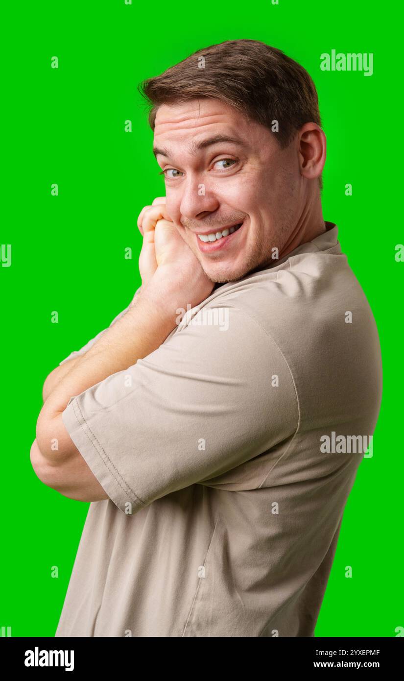 A cheerful man with a friendly smile poses against a bright green ...