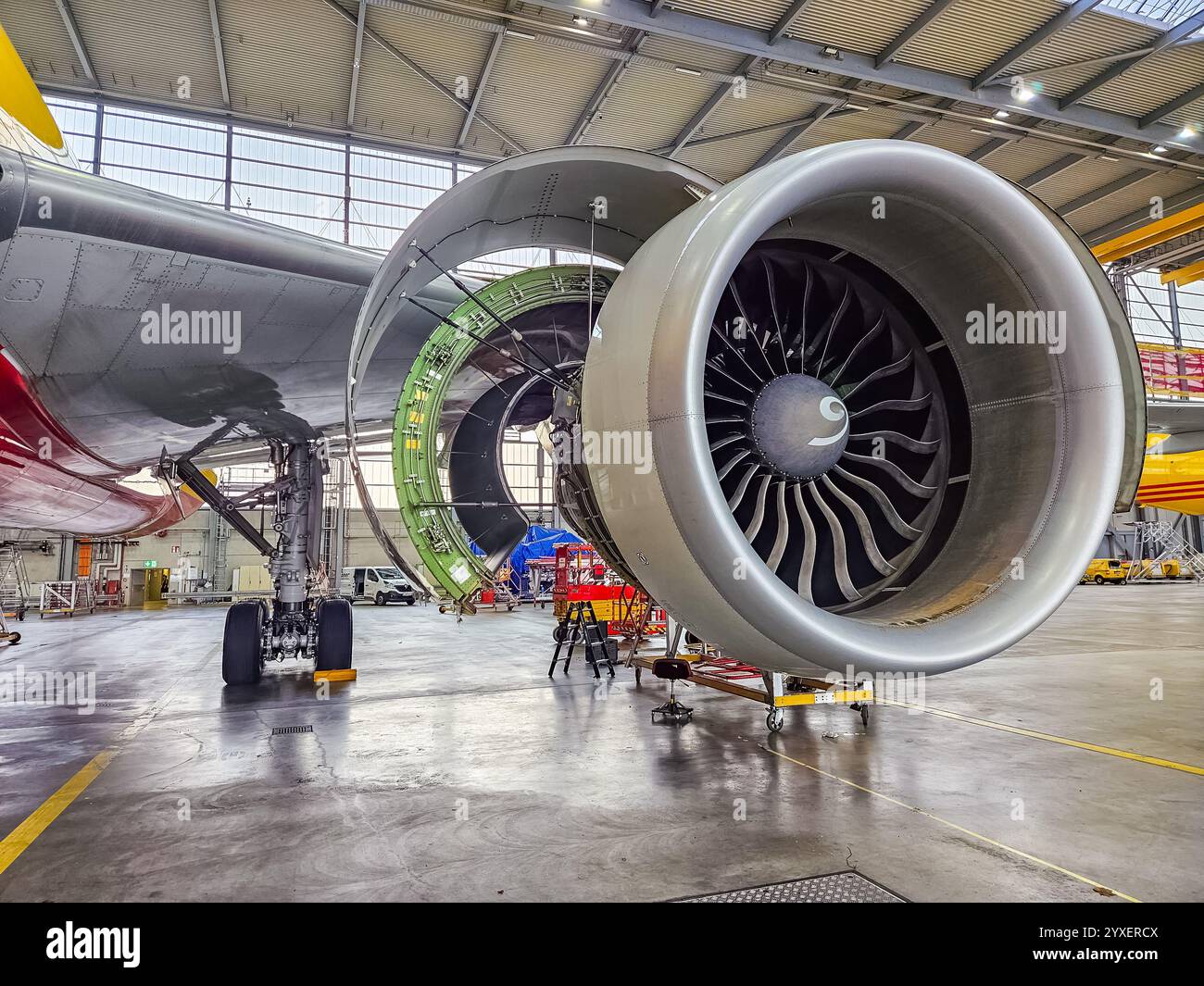 Aircraft engine servicing in hangar, with various tools and equipment ...