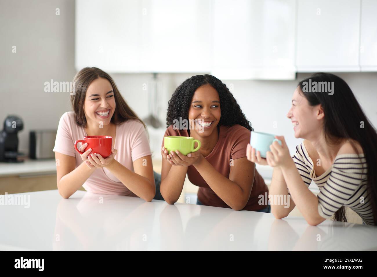 Three women talking and laughing in the kitchen at home Stock Photo - Alamy