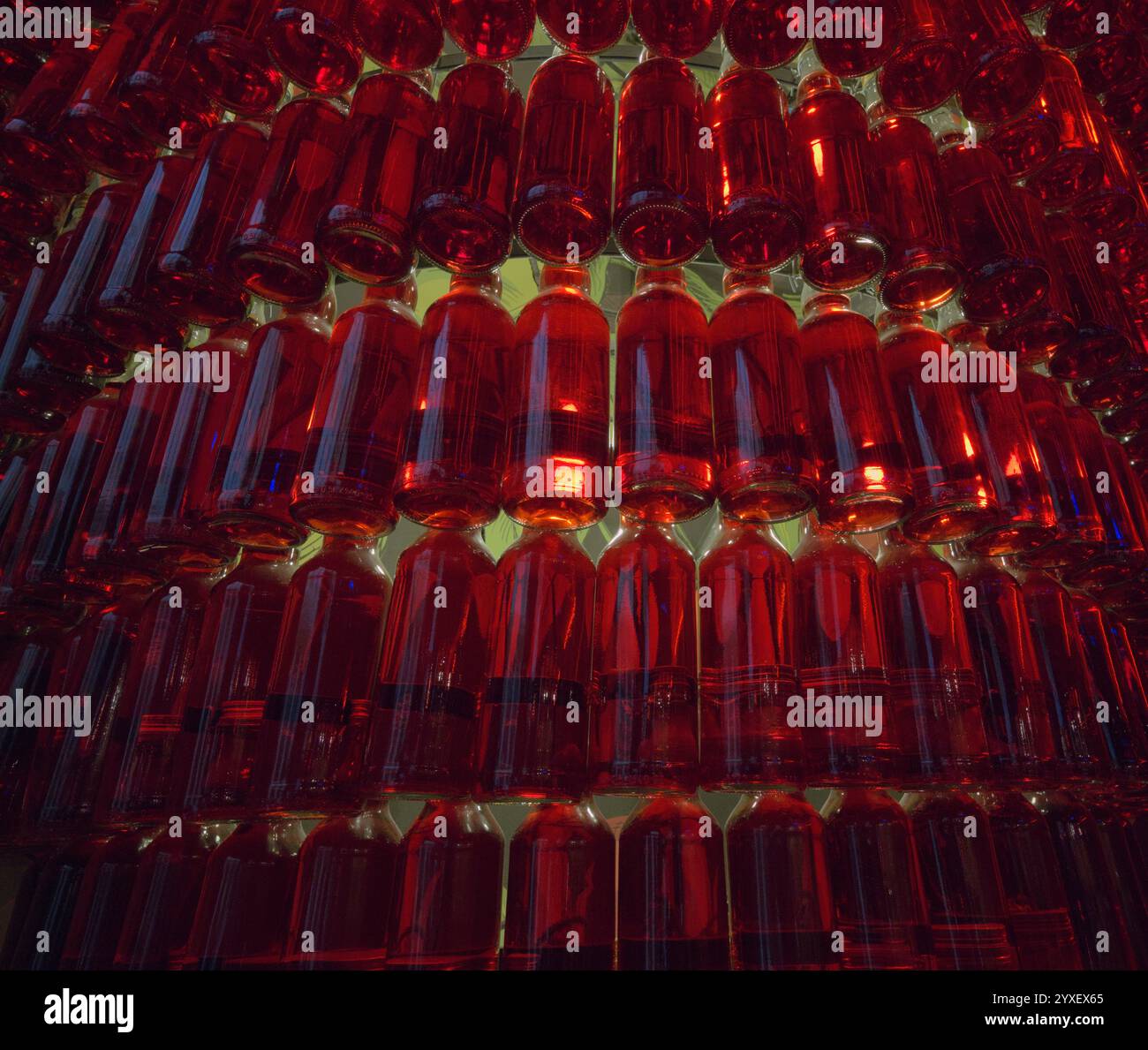 Abstract arrangement of red glass bottles with light reflections ...