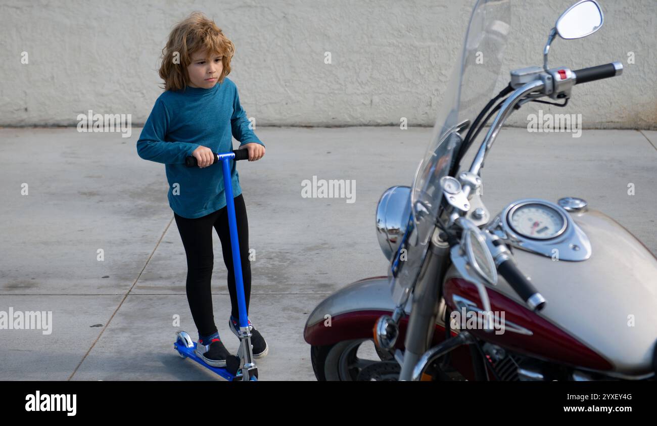Kid future. The surprised child saw a big motorcycle outdoor. His dream ...