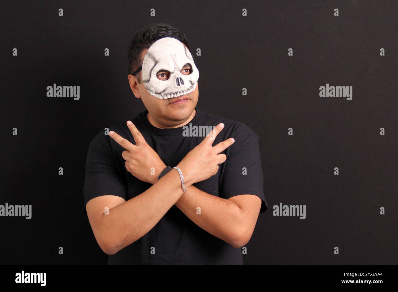 Mexican adult man wears skull mask and makes victory sign with fingers ...