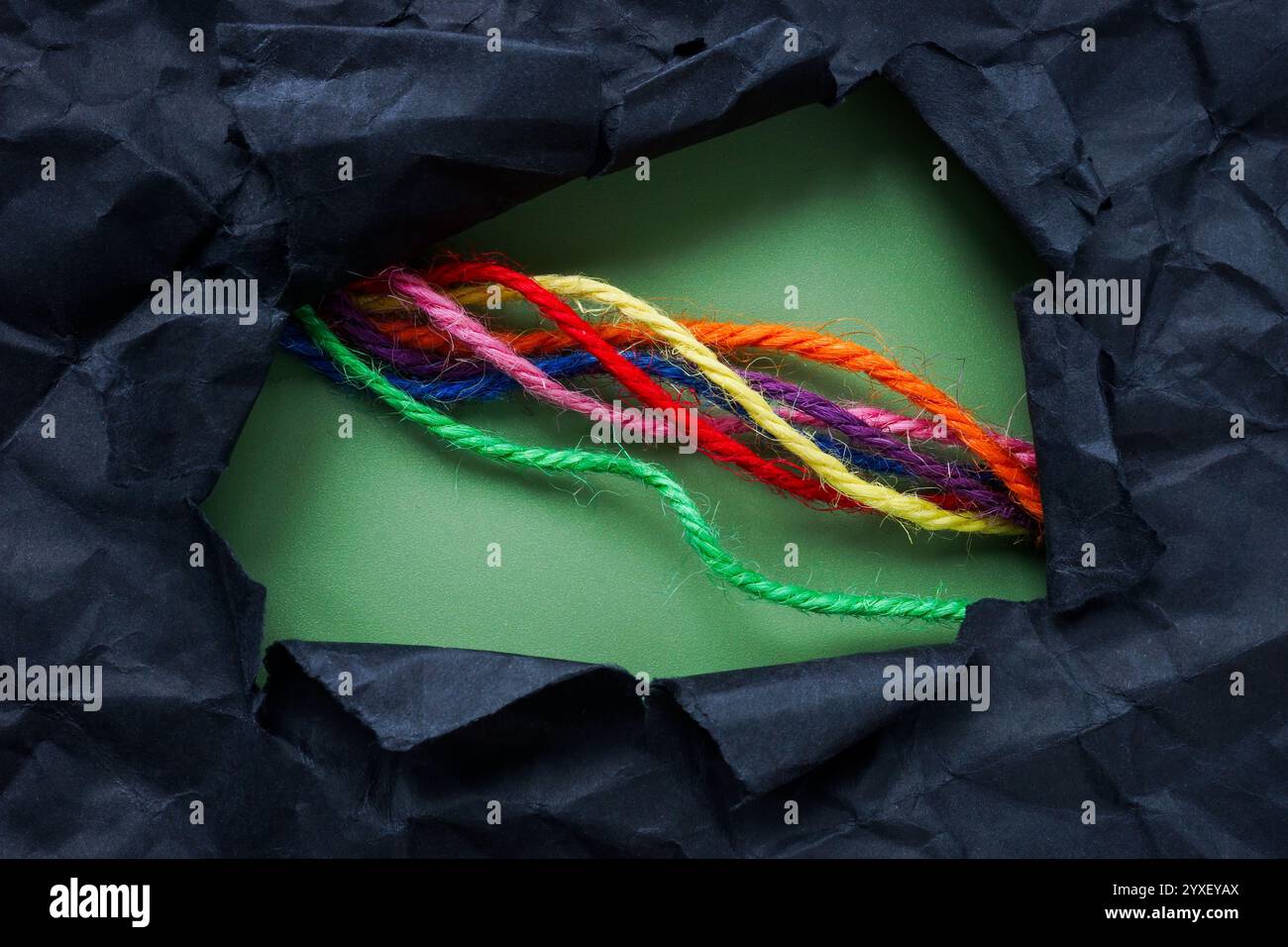 Colorful threads and torn black paper. Creativity and problem ...