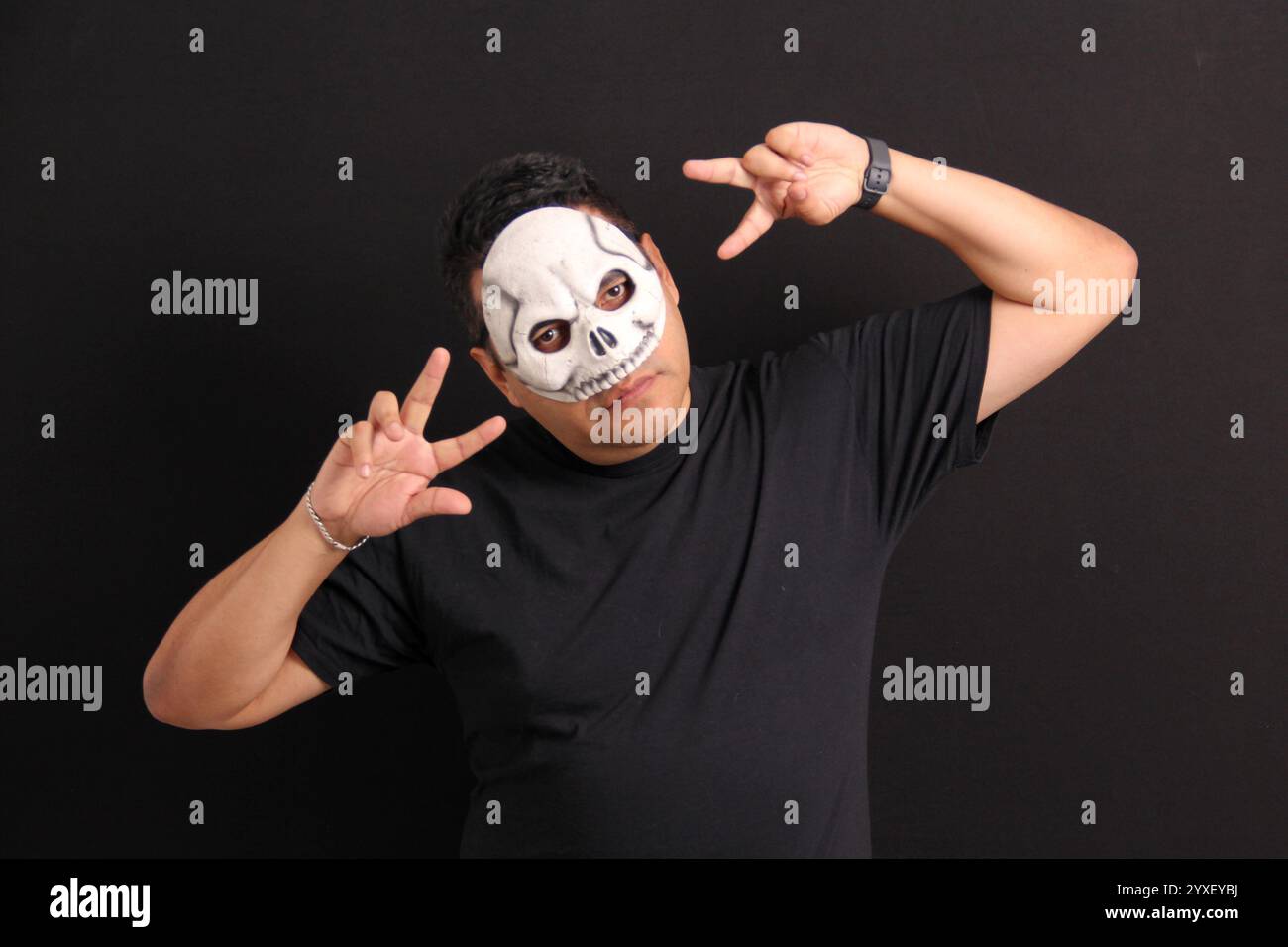 Mexican adult man wears skull mask and makes victory sign with fingers ...