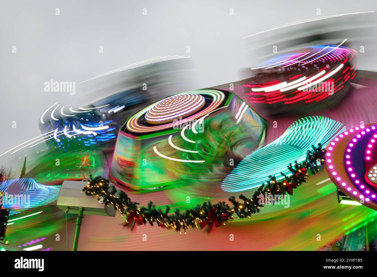 London, UK. 15th Dec, 2024. A vibrant fairground ride illuminates the ...