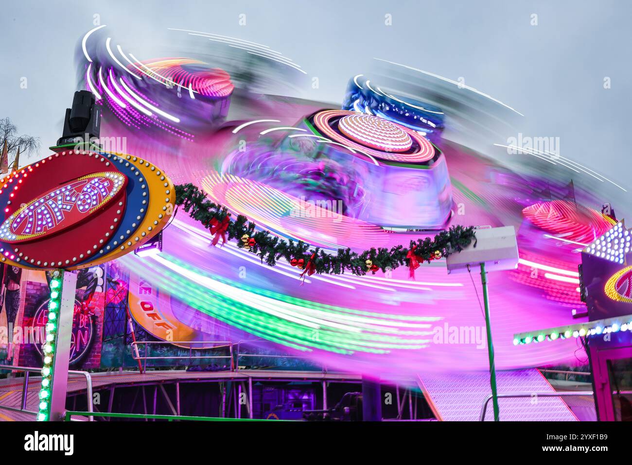 London, UK. 15th Dec, 2024. A vibrant fairground ride illuminates the ...