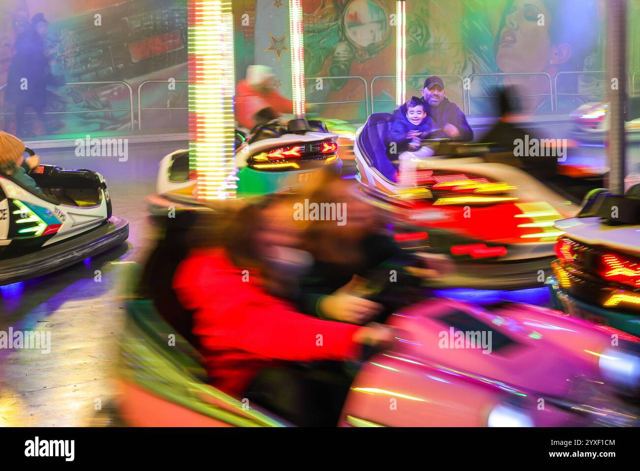 London, UK. 15th Dec, 2024. A vibrant fairground ride illuminates the ...
