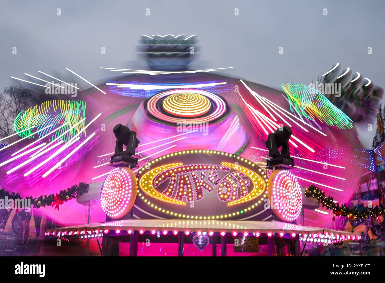 London, UK. 11th Dec, 2024. A vibrant fairground ride illuminates the ...