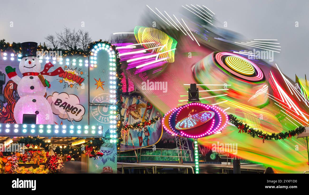 London, UK. 15th Dec, 2024. A vibrant fairground ride illuminates the ...