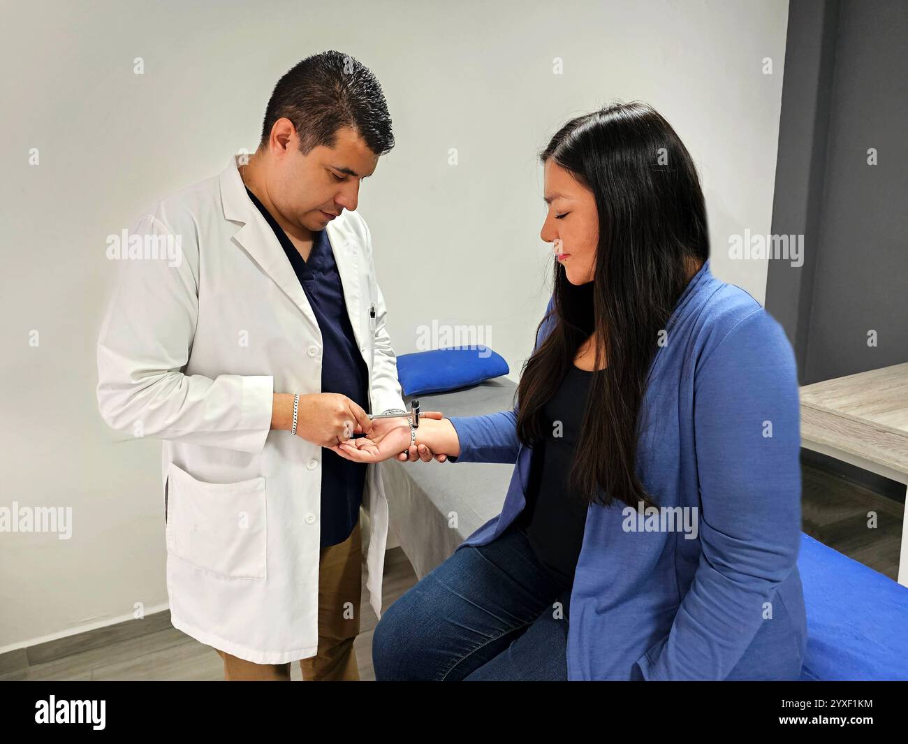 Male brunette specialist doctor checks his latin woman patient ...