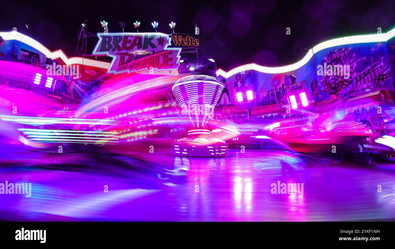 London, UK. 15th Dec, 2024. A vibrant fairground ride illuminates the ...