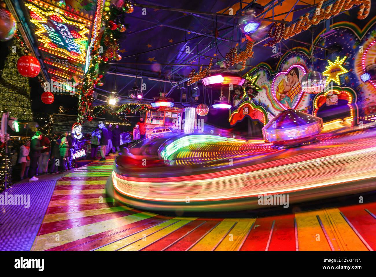 London, UK. 15th Dec, 2024. A vibrant fairground ride illuminates the ...