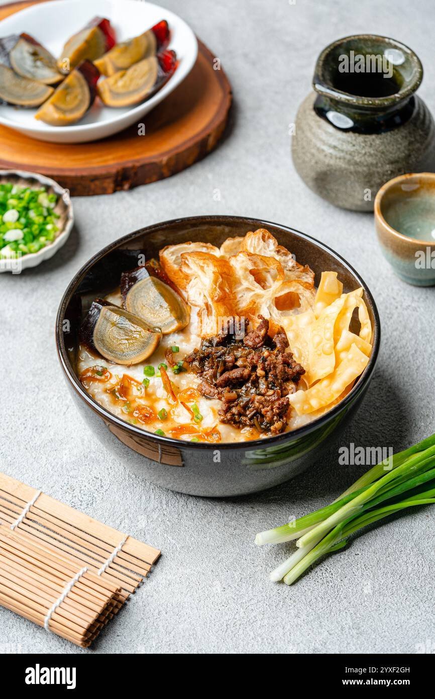 Rice porridge or congee with minced pork, century egg and cakwe in bowl ...
