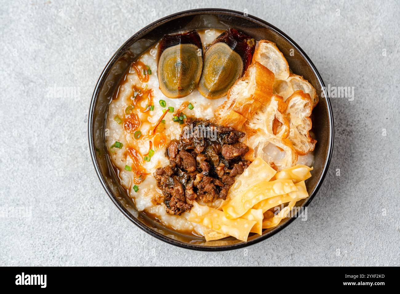 Rice porridge or congee with minced pork, century egg and cakwe in bowl ...