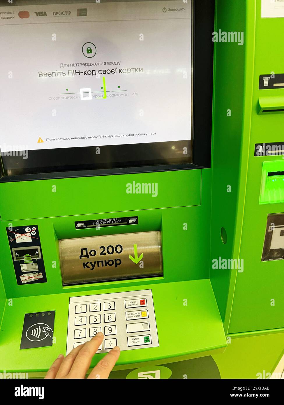 Kyiv, Ukraine - December 15, 2024: Person using an ATM machine by ...