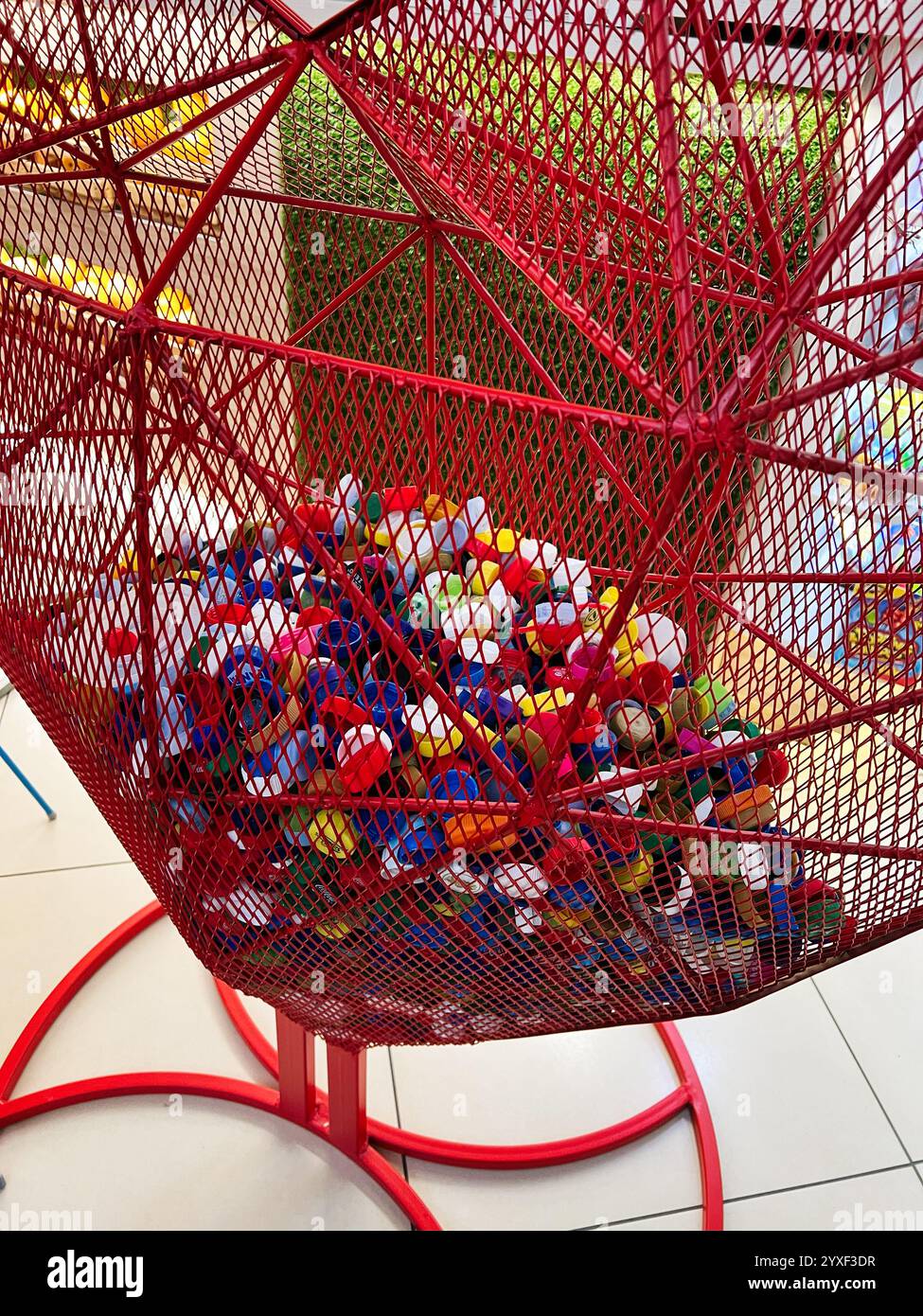 Close-up of a red wire mesh container filled with vibrant plastic ...