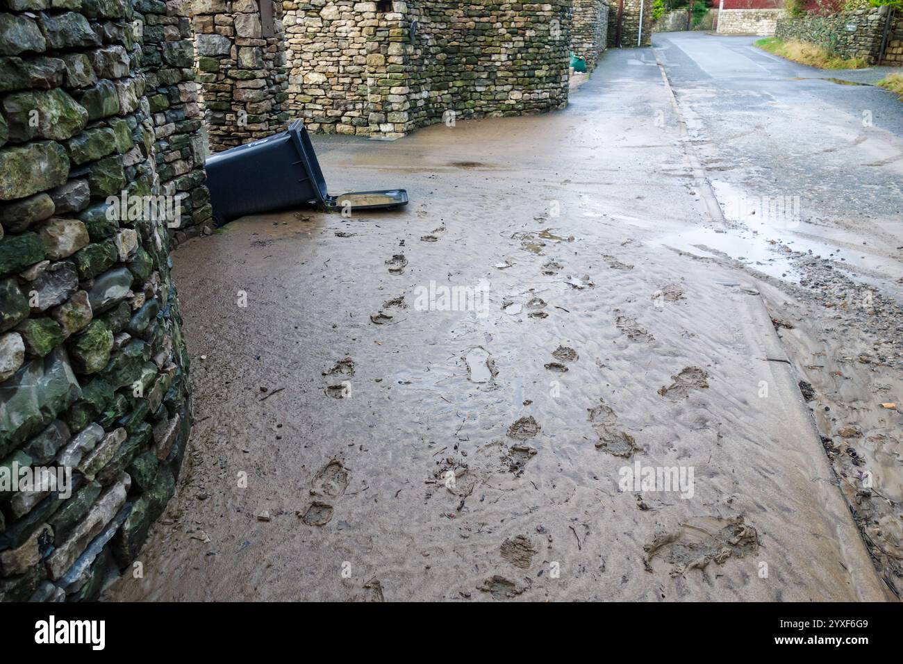 Footprints in mud and silt left on a footpath after a flooding due to a ...
